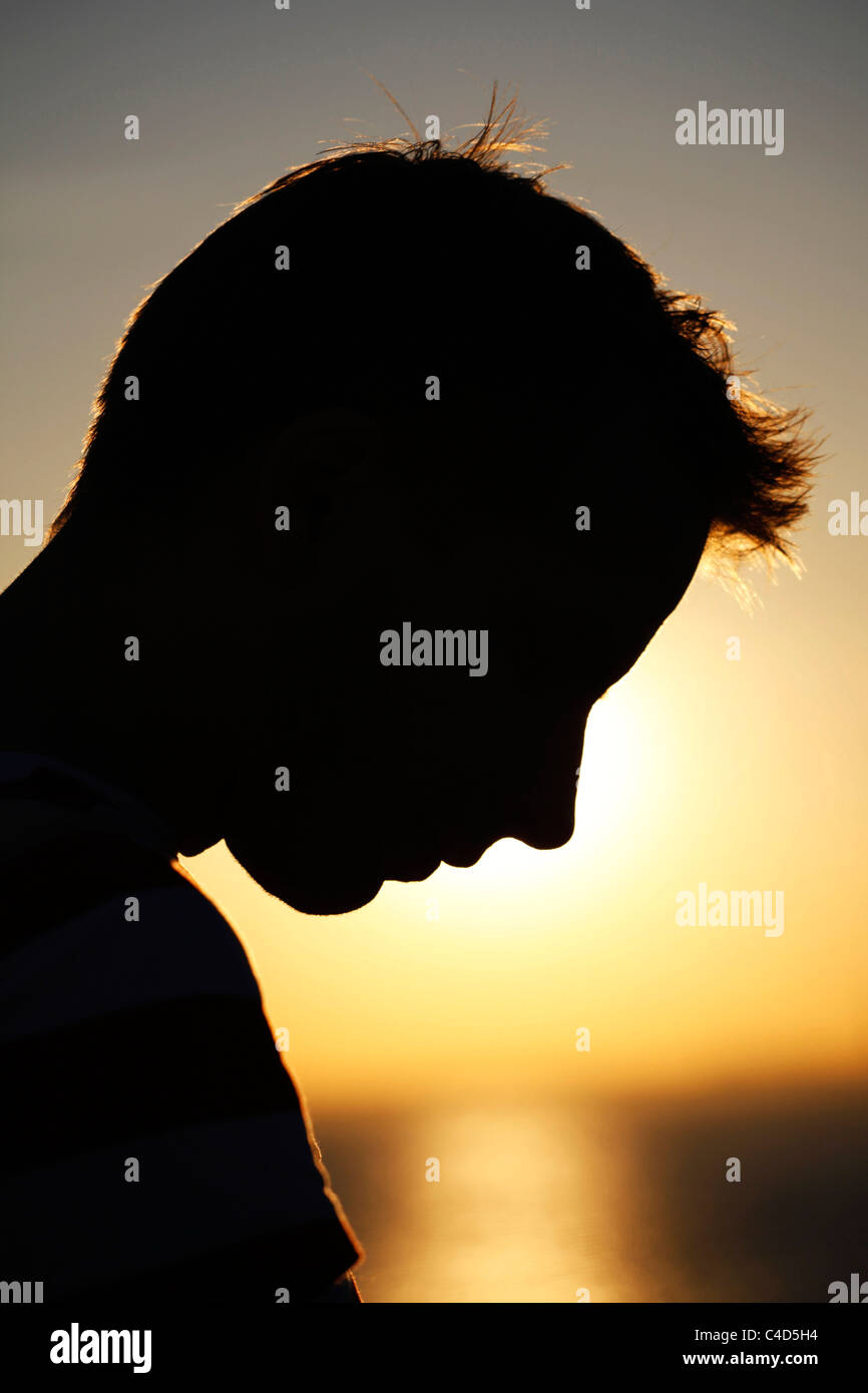 Anonymous silhouette of the head and face of a man against the sun at ...
