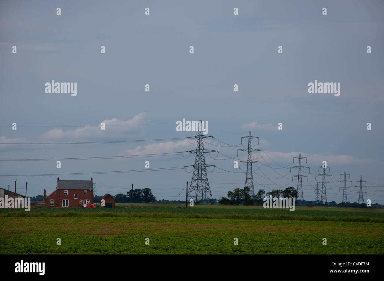 House with electricity pylons Stock Photo - Alamy