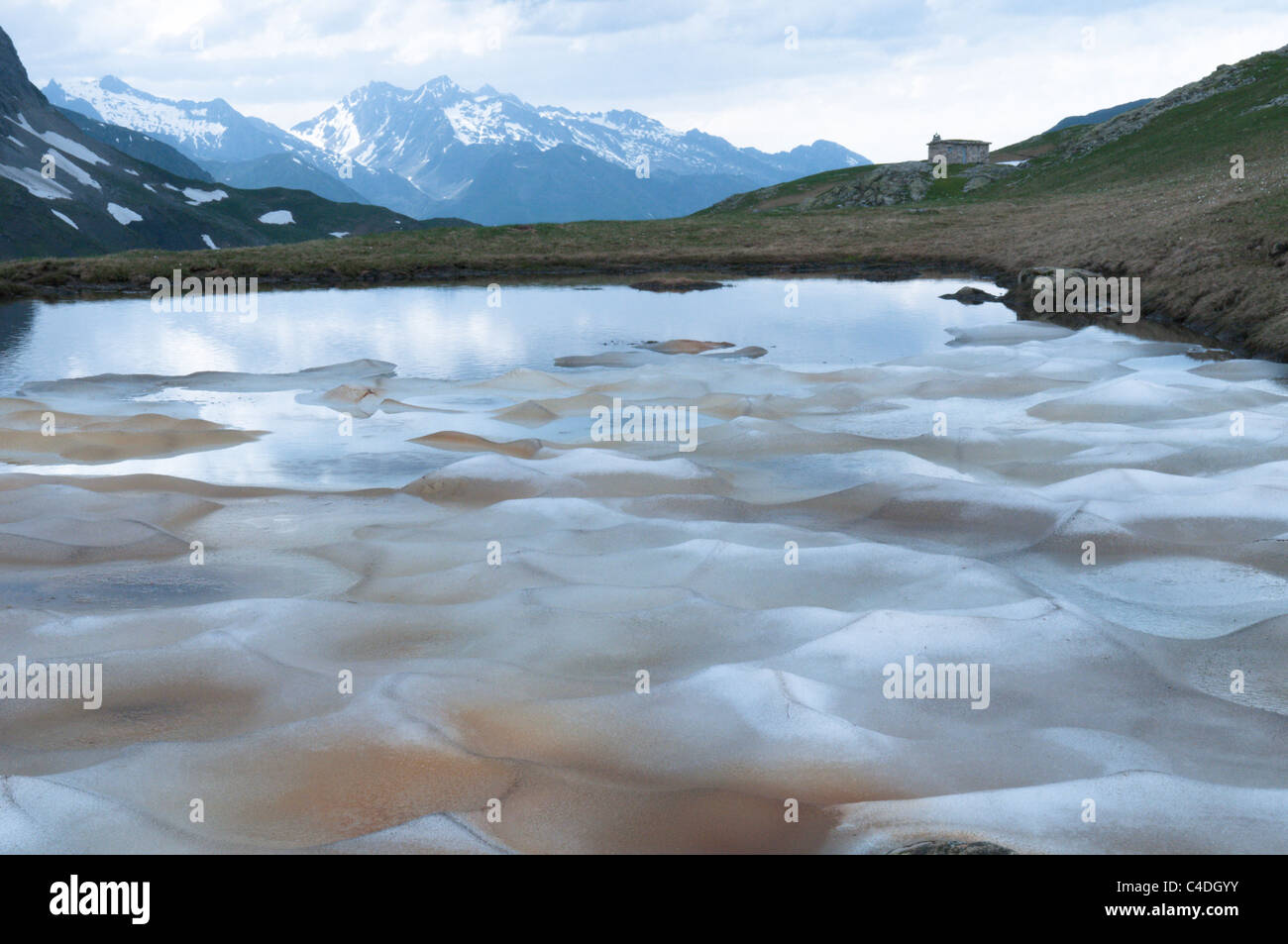 Melting snow and ice on pool of water in Le Cirque de Troumouse. Park ...