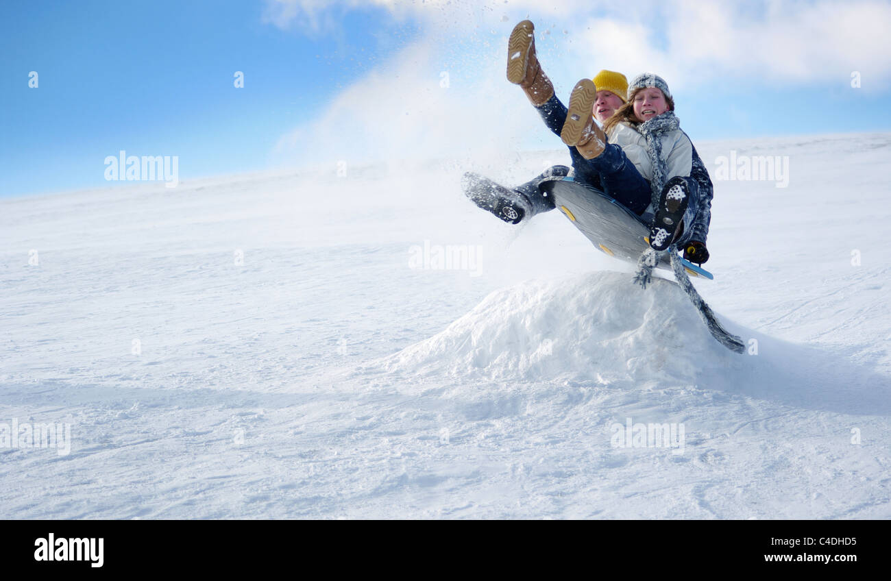 Two children sledding as they go off of a snow jump Stock Photo - Alamy