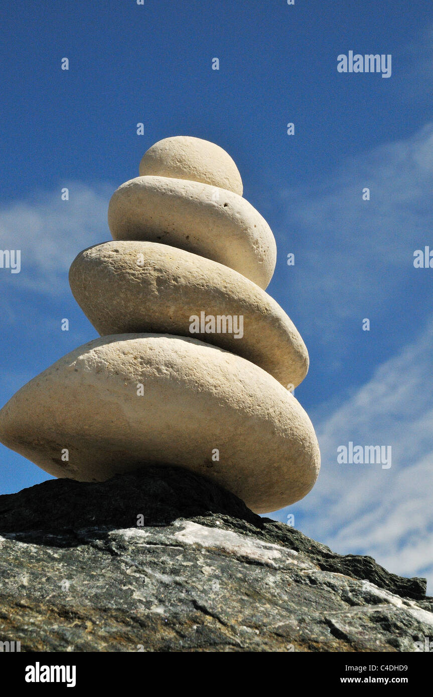 Balanced stack of rocks against a blue sky Stock Photo - Alamy