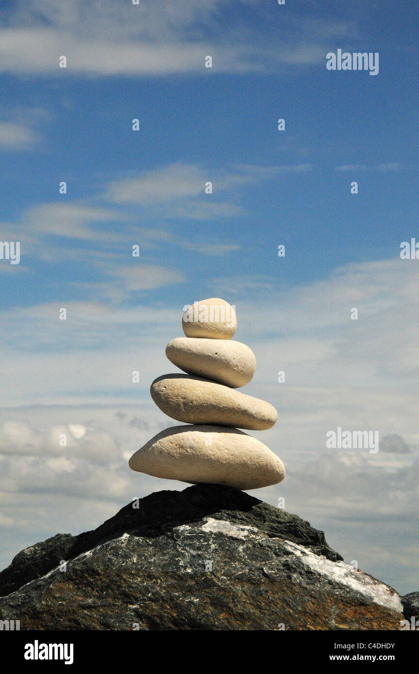 Balanced stack of rocks against a blue sky Stock Photo - Alamy