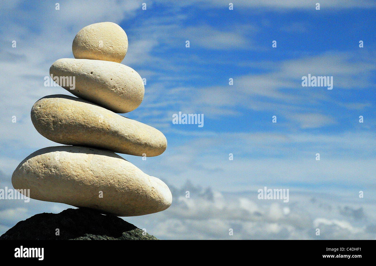 Balanced stack of rocks against a blue sky Stock Photo - Alamy