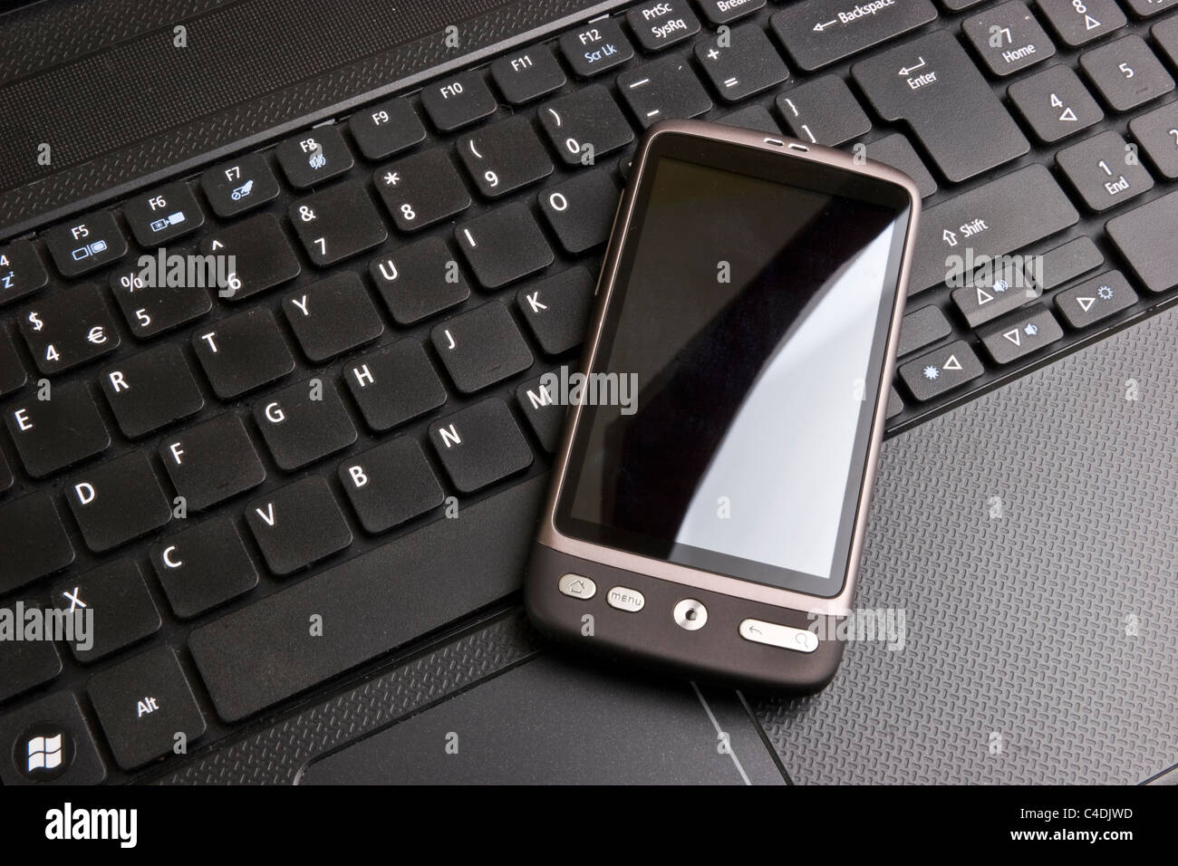 Smartphone on a laptop keyboard Stock Photo - Alamy