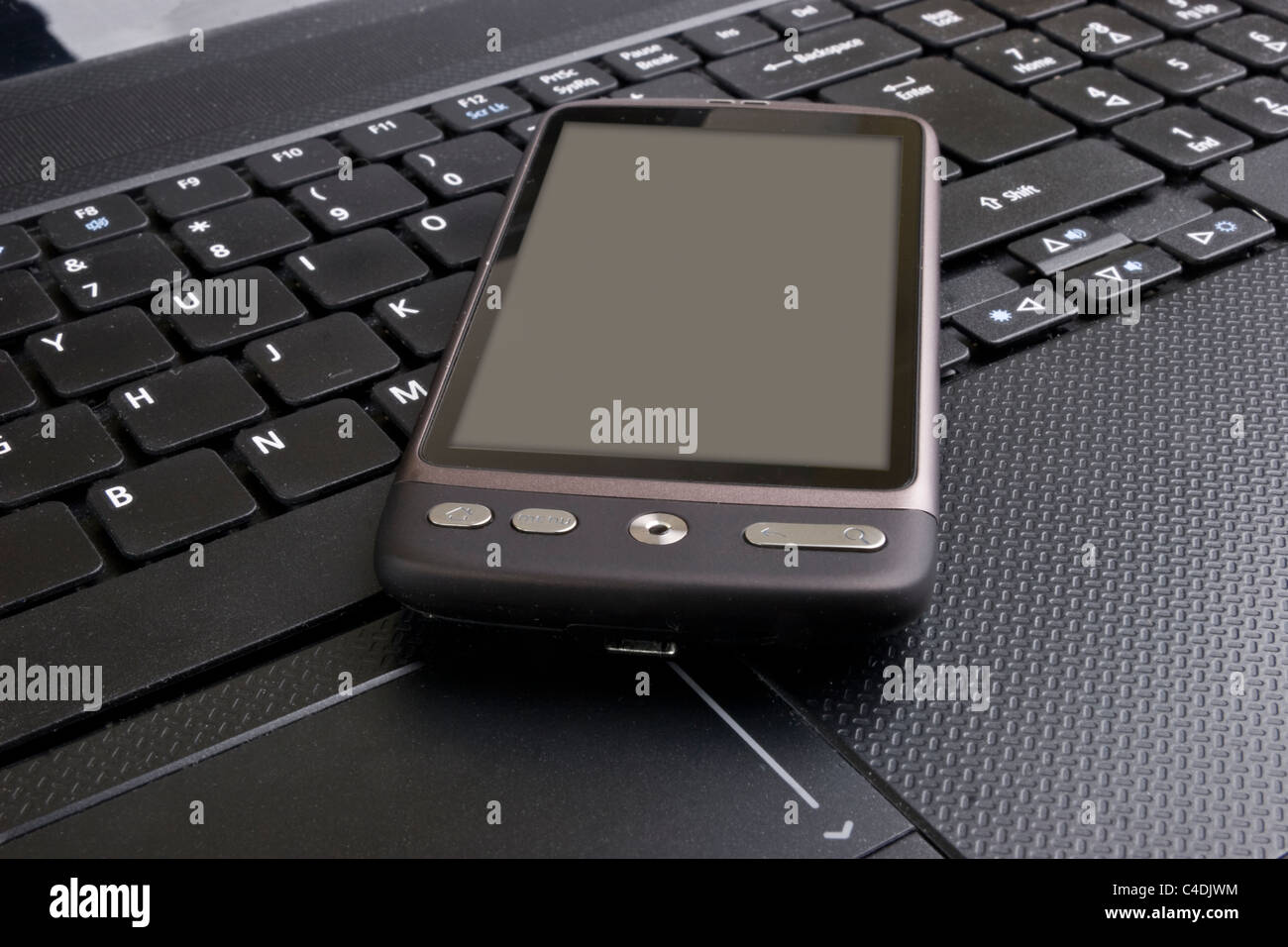 Smartphone on a laptop keyboard Stock Photo - Alamy