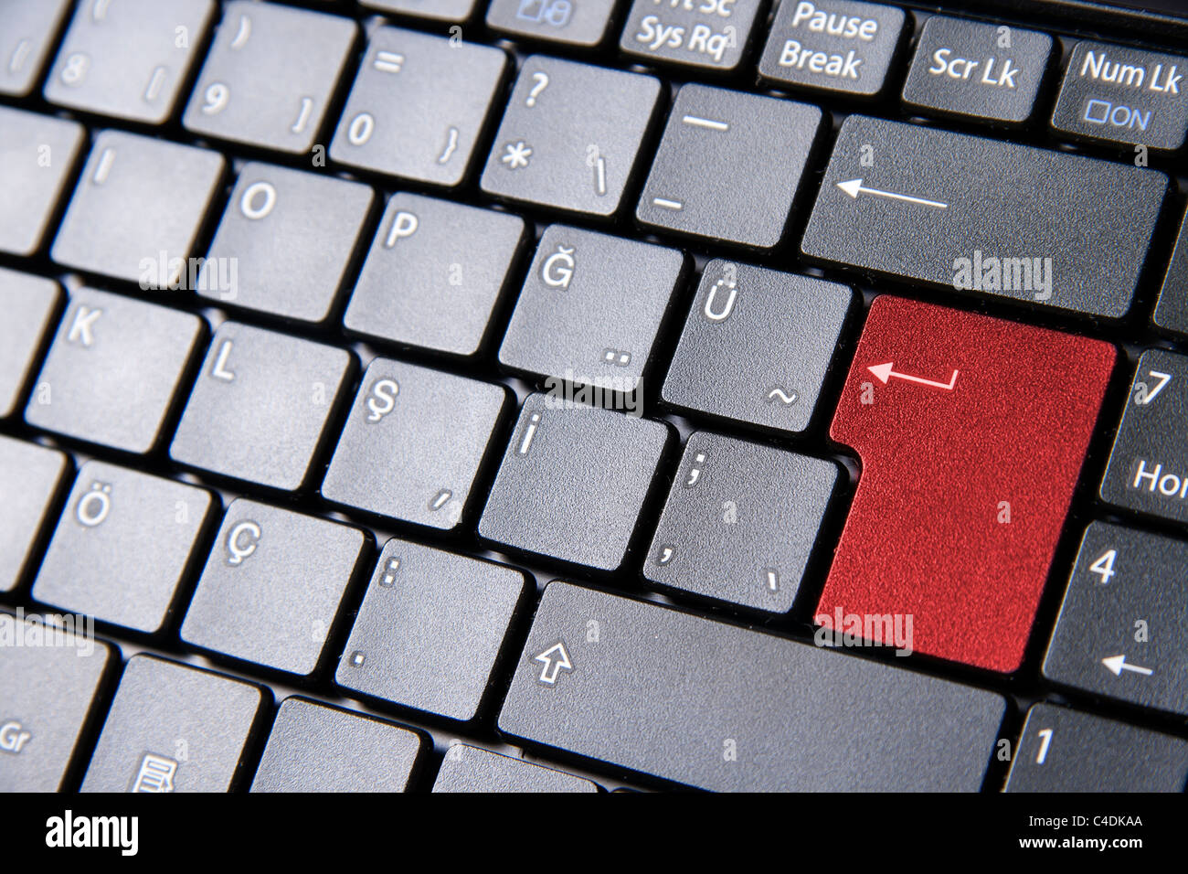 A close up to a laptop keyboard with a red enter key Stock Photo - Alamy