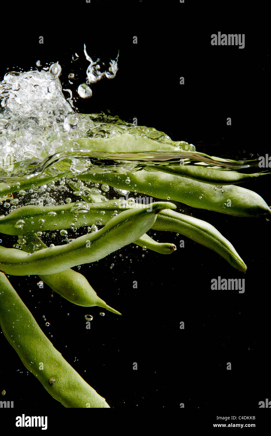 Fresh beans thrown into water to clean Stock Photo - Alamy