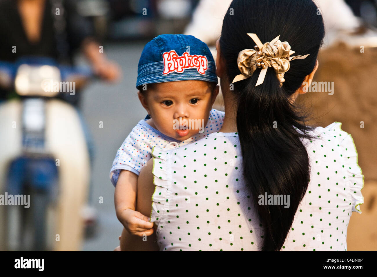 Baby being carried by mother Stock Photo - Alamy