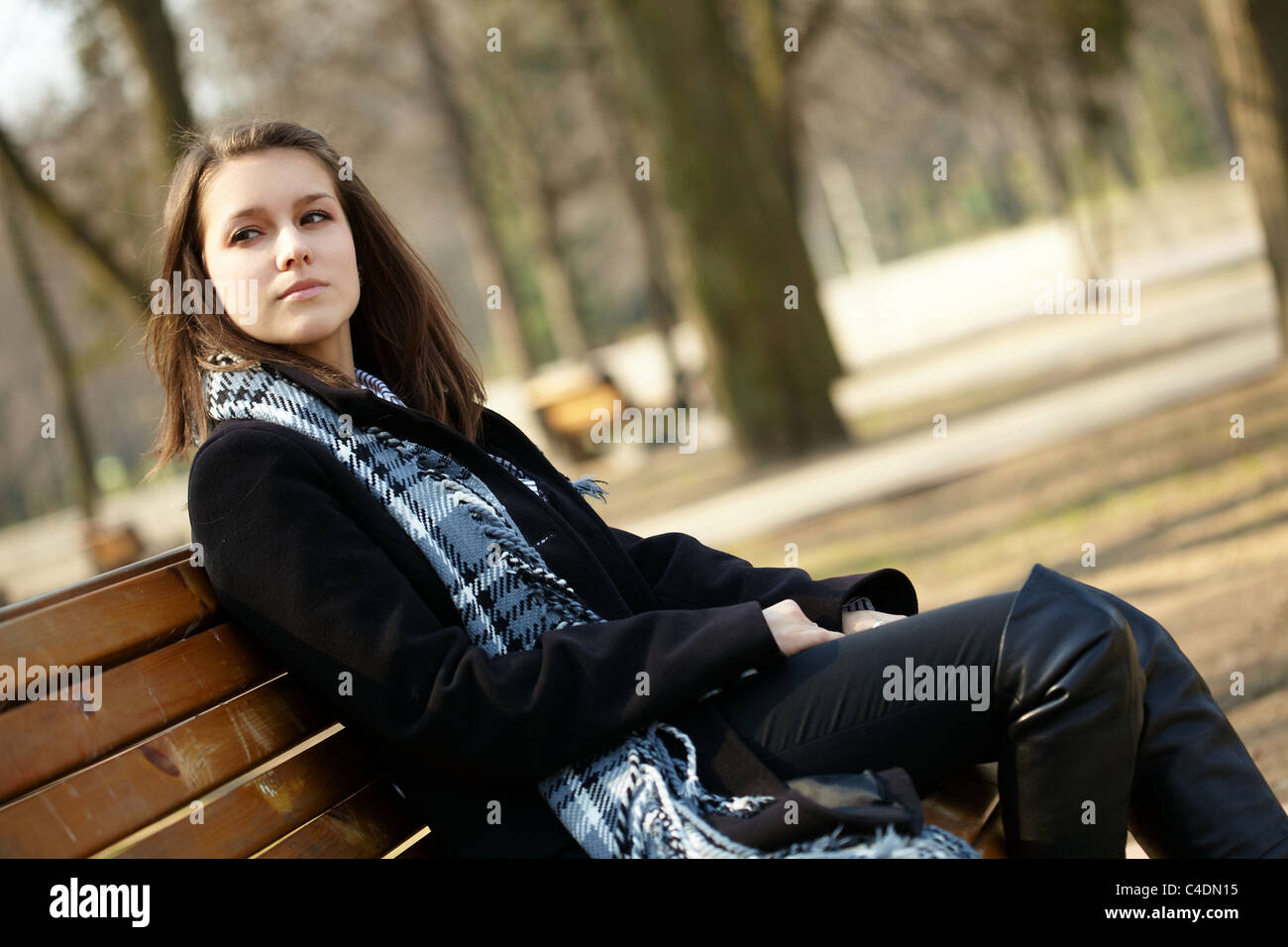 Young girl sitting on bench Stock Photo - Alamy