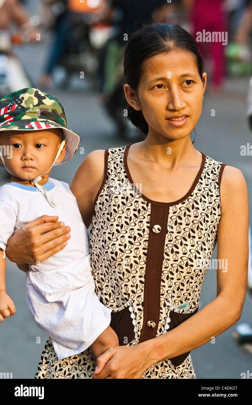 Mother carrying child in the street Stock Photo - Alamy