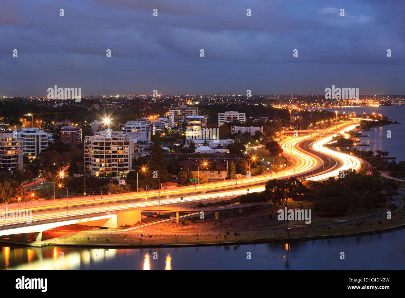 Busy road at night beside houses and apartment buildings Stock Photo ...