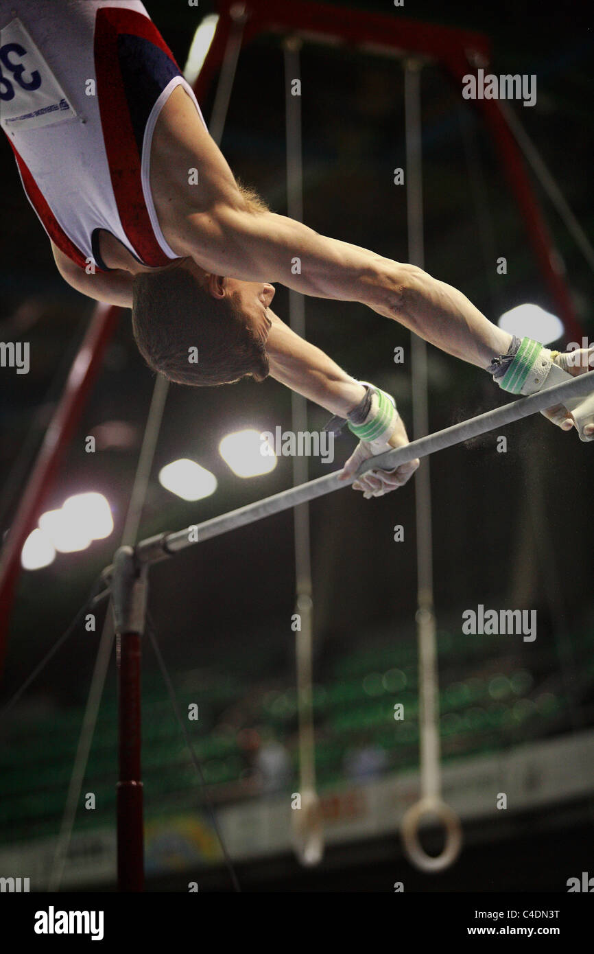 gymnastics competition: a gymnast's performing his high bar routine ...