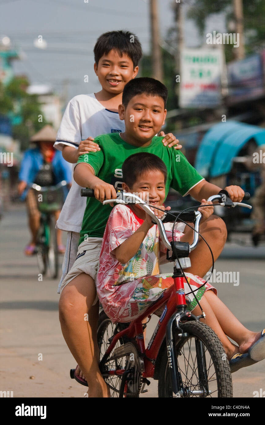 Three boys riding on bicycle Stock Photo - Alamy