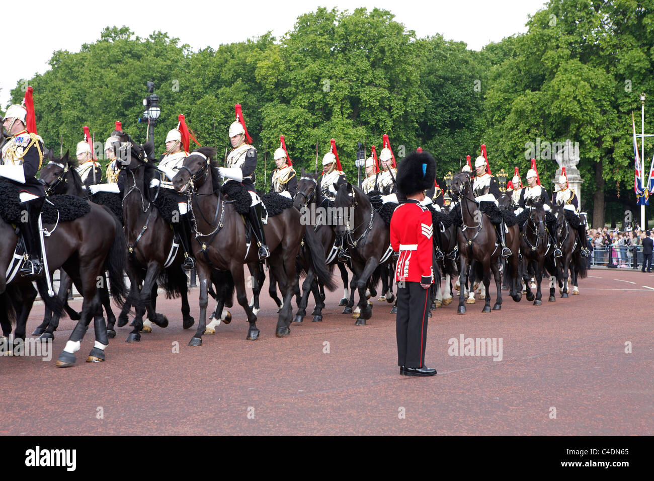 Lone soldier on guard as guardsman pass on horseback during the ...