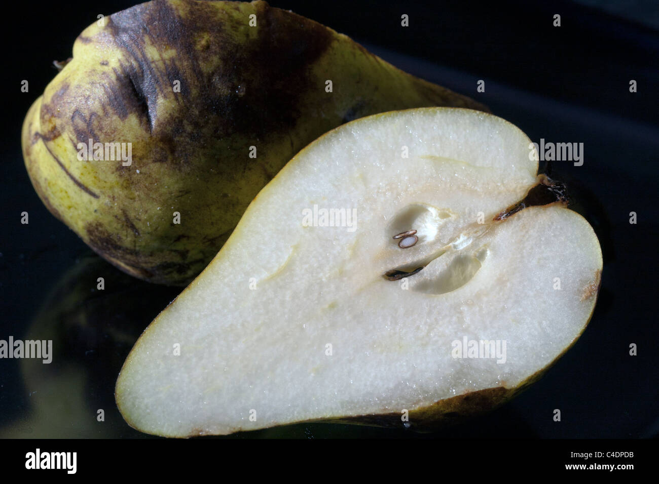 Pear cut in half and placed in black dish Stock Photo - Alamy