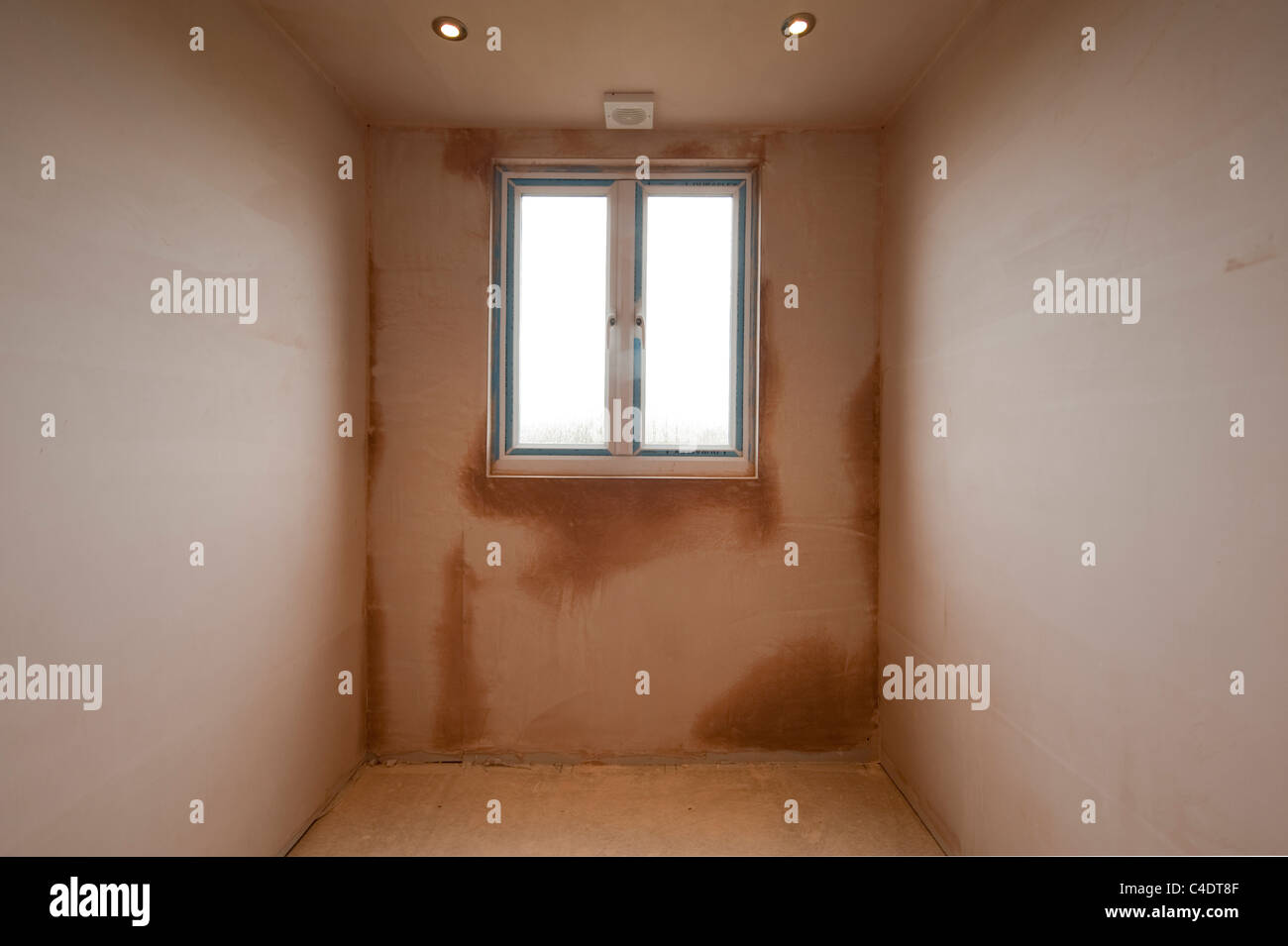 Newly plastered room with window and LED downlights awaiting decoration ...