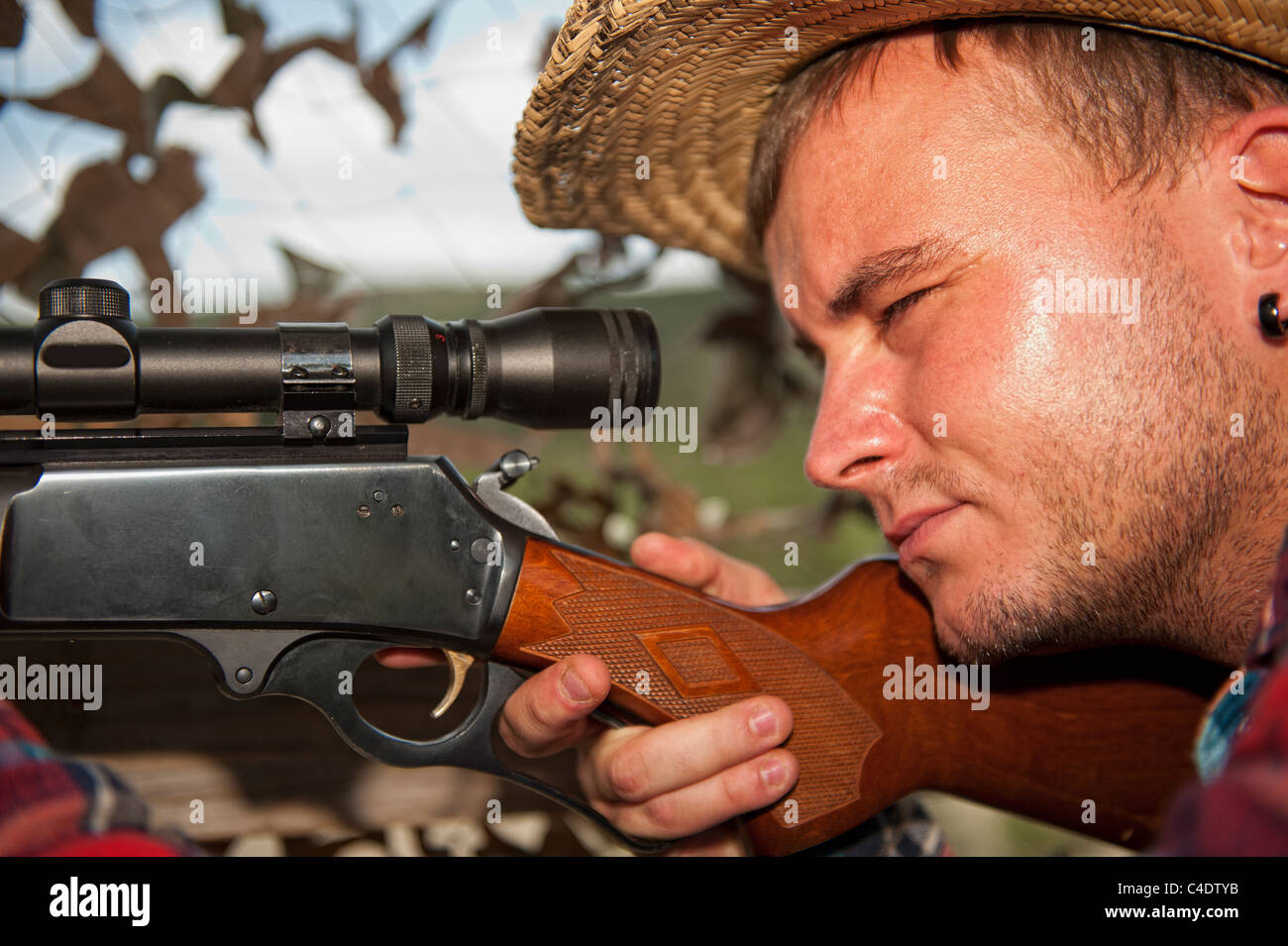 Young man with firearm aiming at target Stock Photo - Alamy