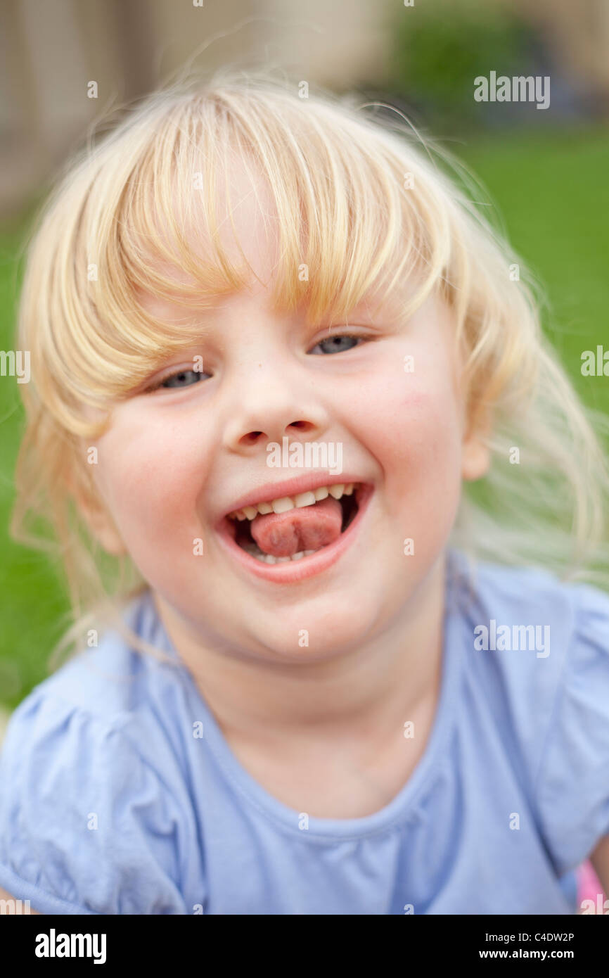 Playful toddler with a mischievous smile sitting in the garden Stock ...