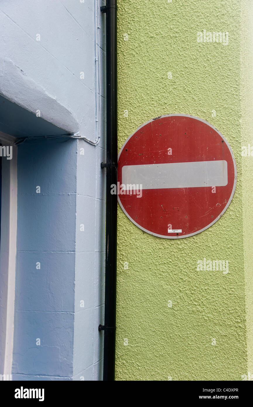 A traffic no-entry sign fixed to a house wall, which is painted green ...