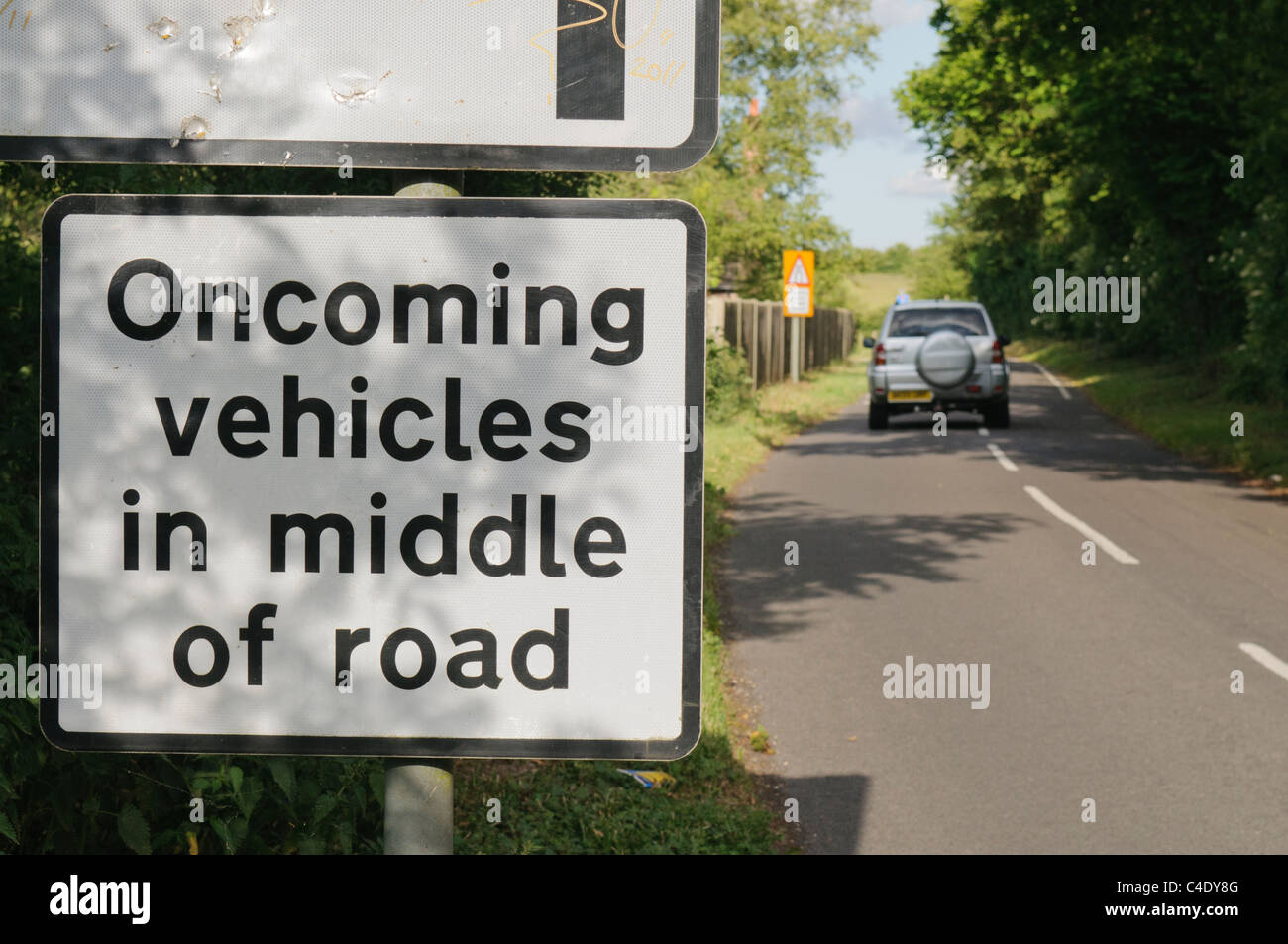 Road sign warning drivers that oncoming vehicles will be in the middle ...
