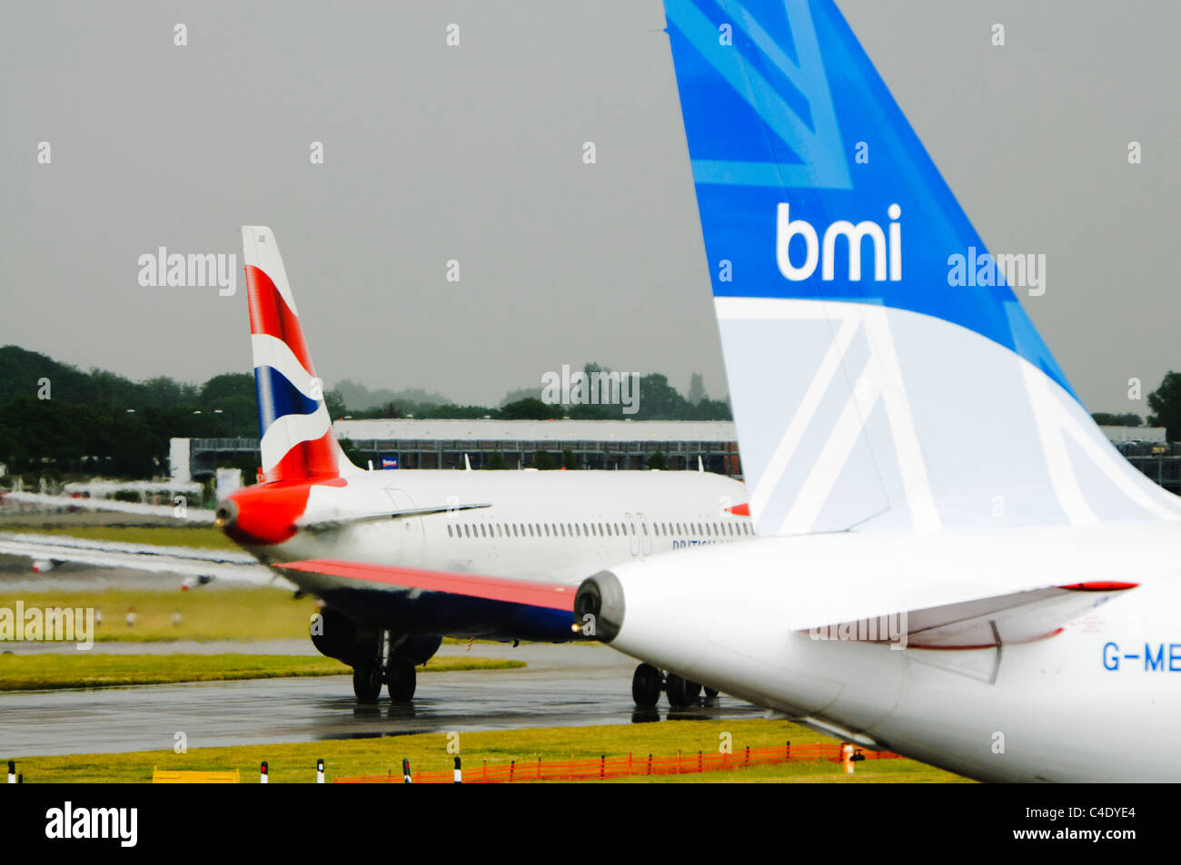 Tail fins of a BMI and a British Airways plane on a runway. BMI were ...