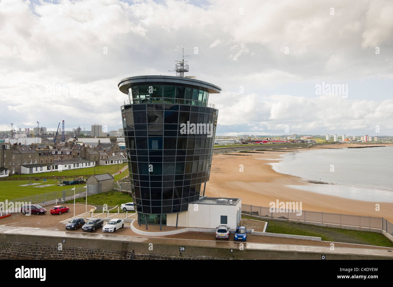 Harbour master's control tower at the entrance to port with beach on ...