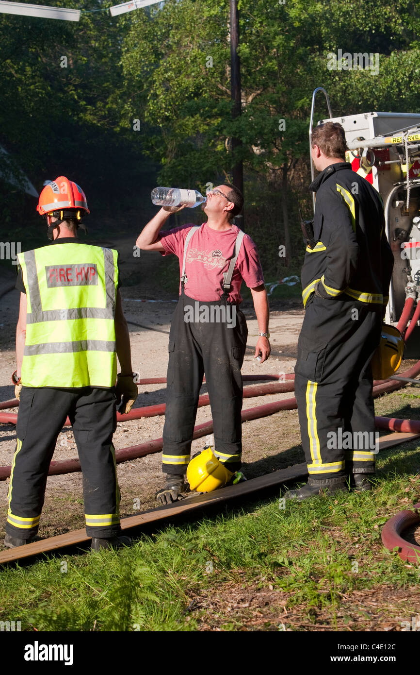 Firefighter taking well earned drink during Swinley Forest fire close ...