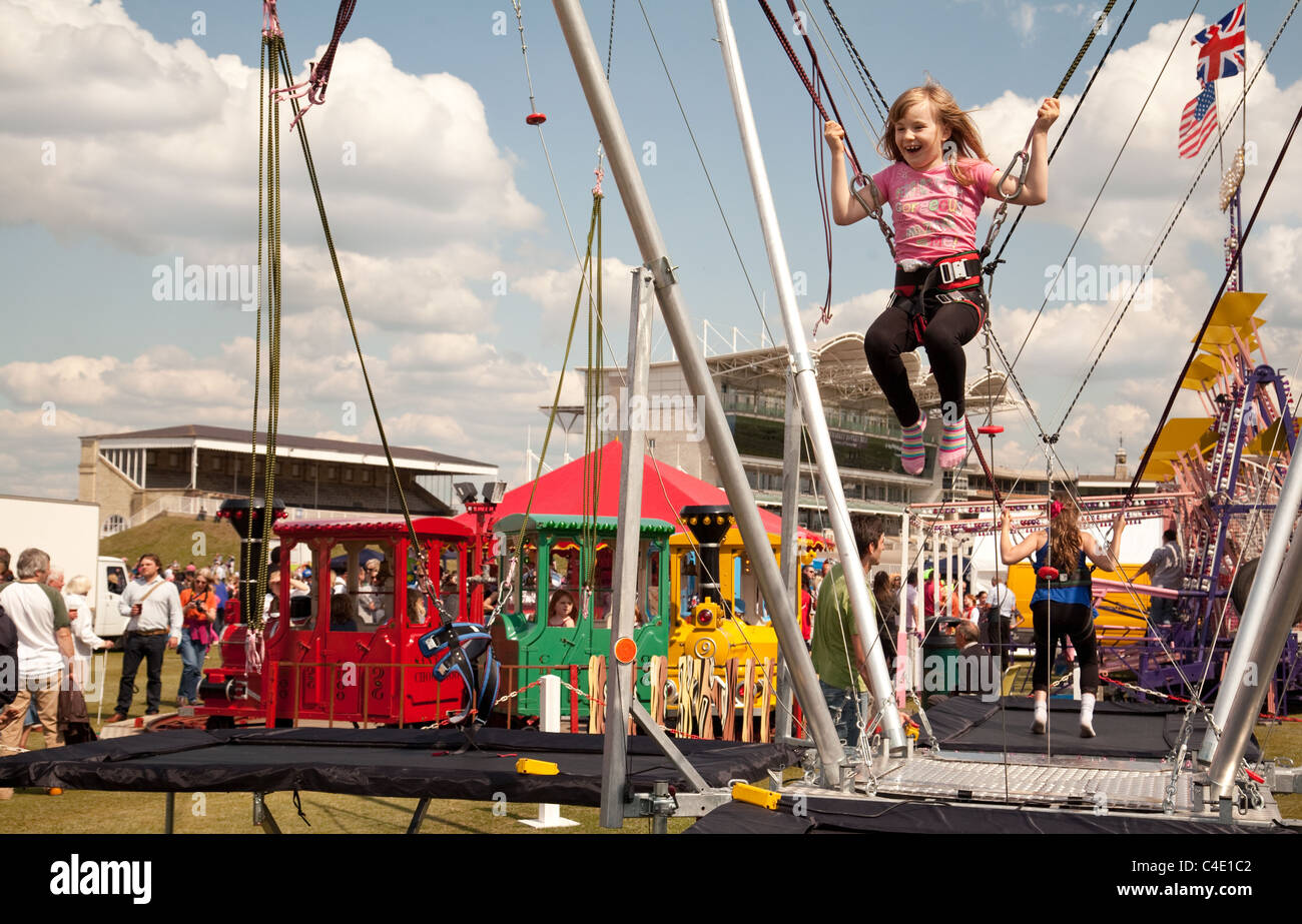 Young girl enjoying the trampoline, Newmarket Town Carnival, Suffolk UK ...