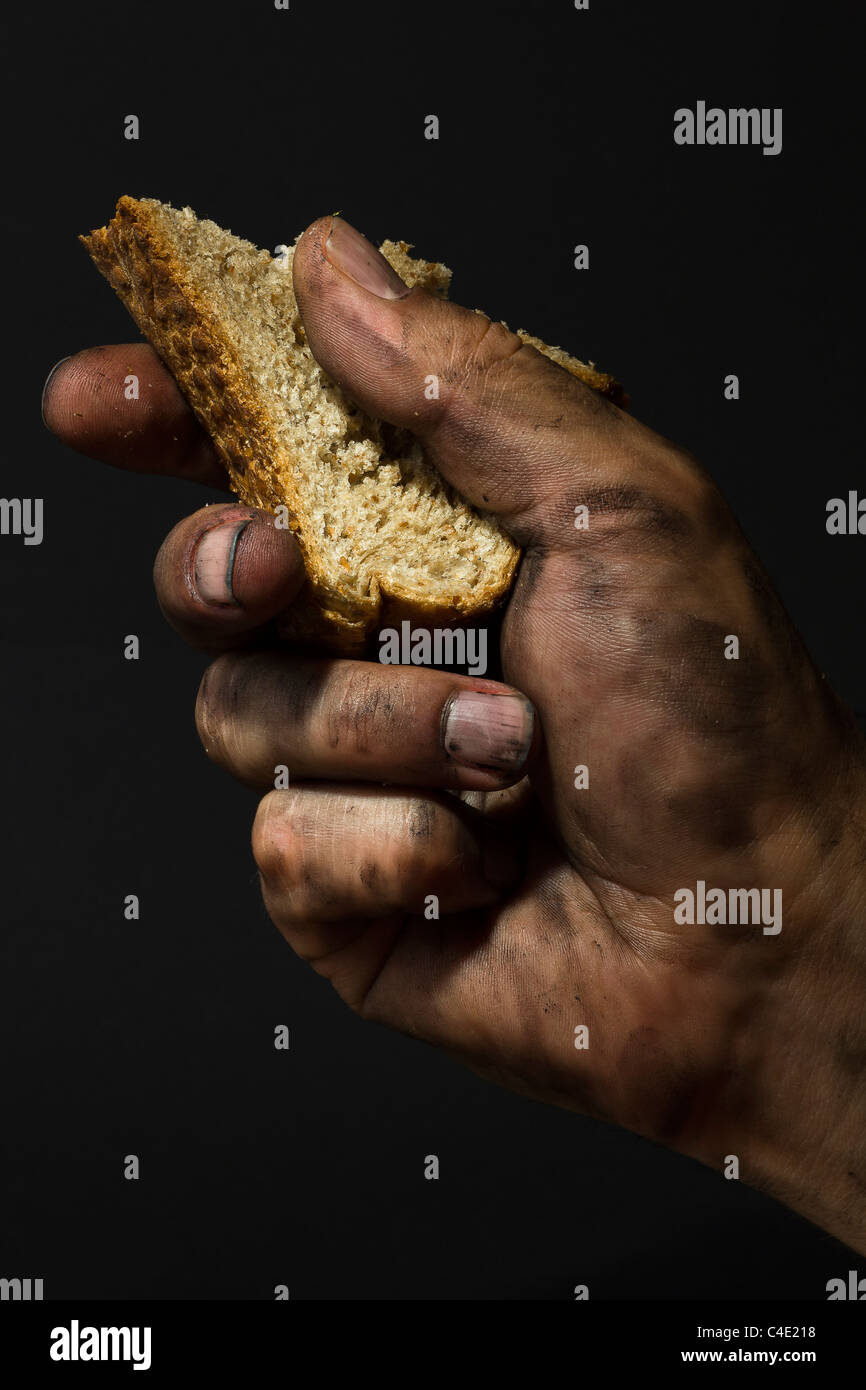 Dirty hand holding a bread on the black background Stock Photo - Alamy