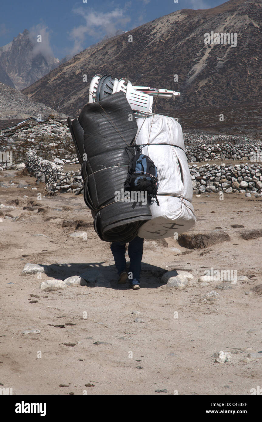 A porter carrying a huge load in the Nepal himalayas Stock Photo - Alamy