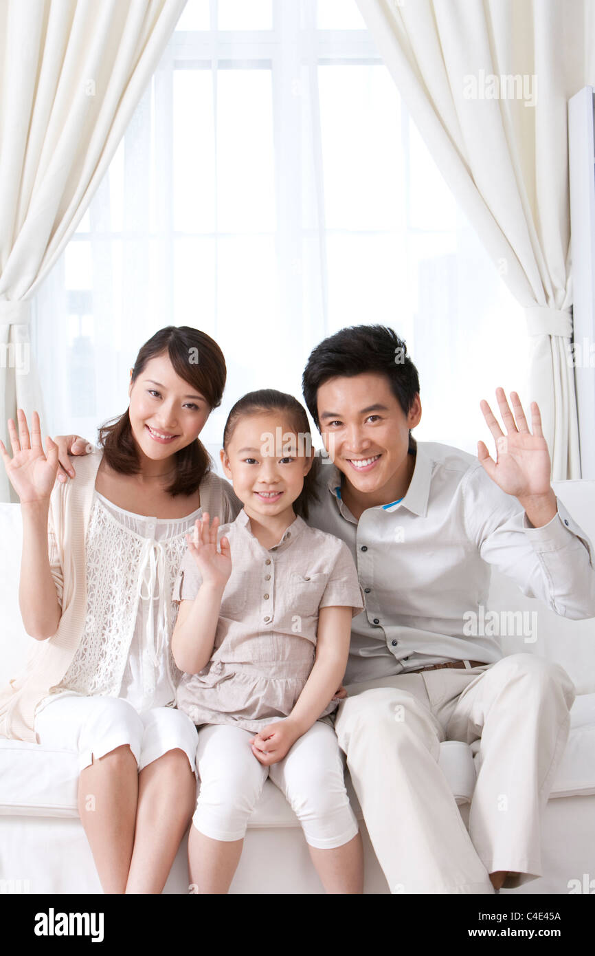 Happy Family Waving on a Sofa Stock Photo - Alamy