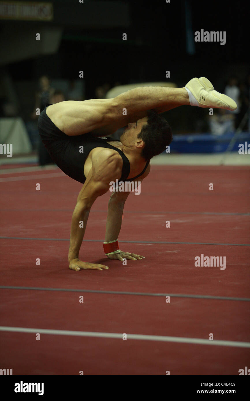 Gymnastics competition: a gymnast is performing a difficult static ...