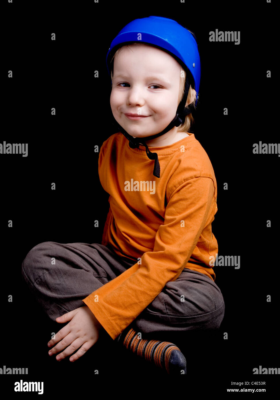 Cute little boy in blue helmet on black background Stock Photo - Alamy