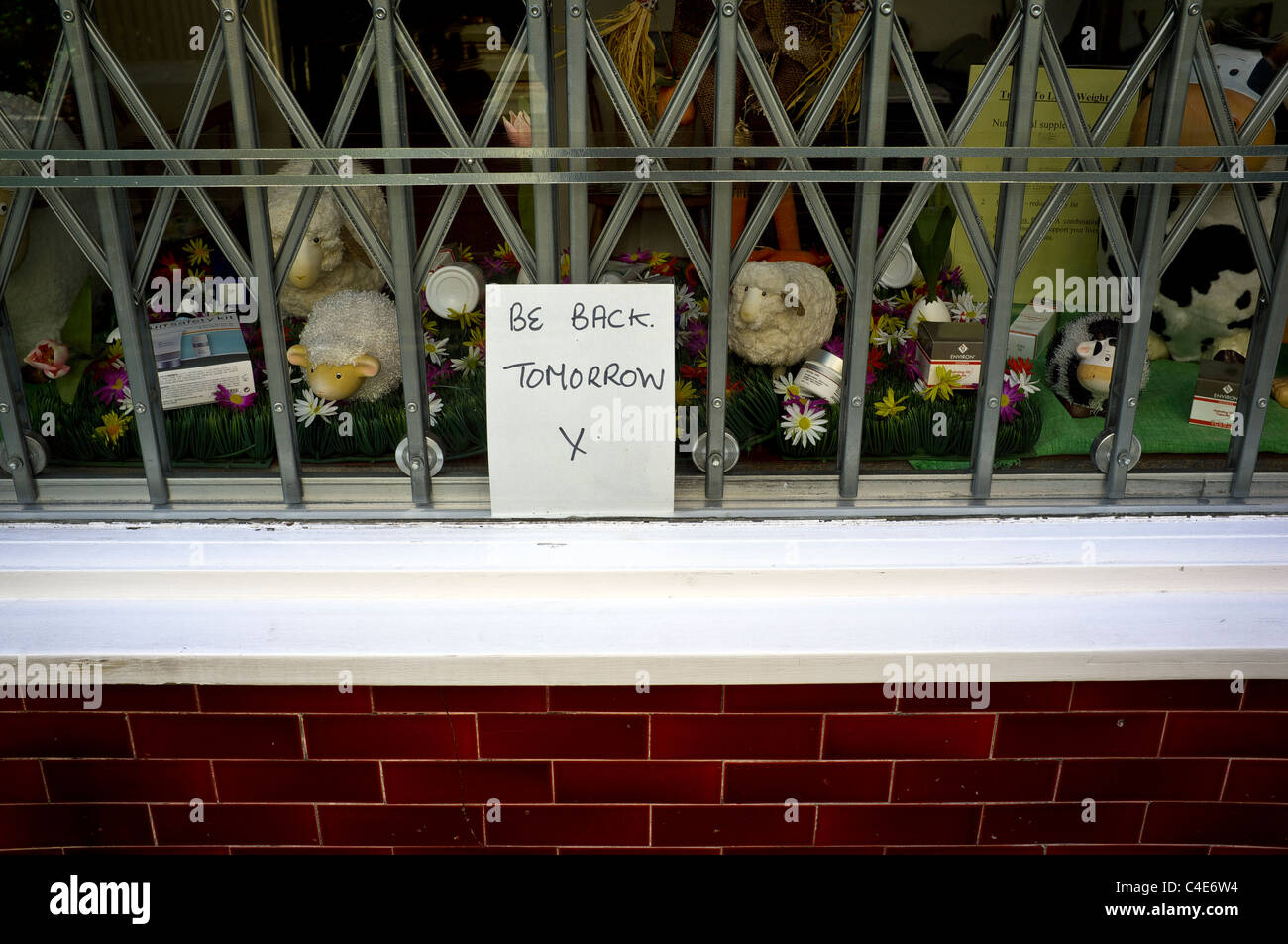 Closed shop with a 'be back tomorrow' sign in window Stock Photo - Alamy