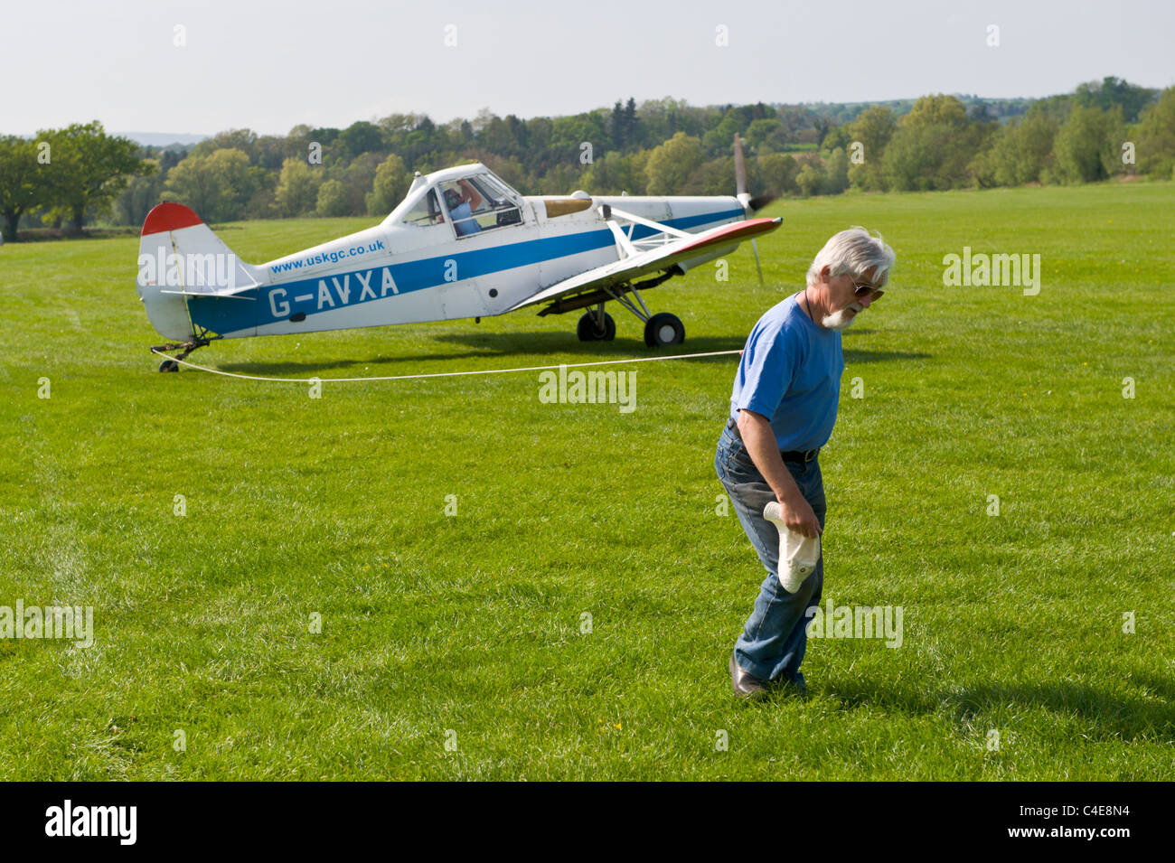 Ground crew pulling out cable from tug aircraft to attach to glider ...