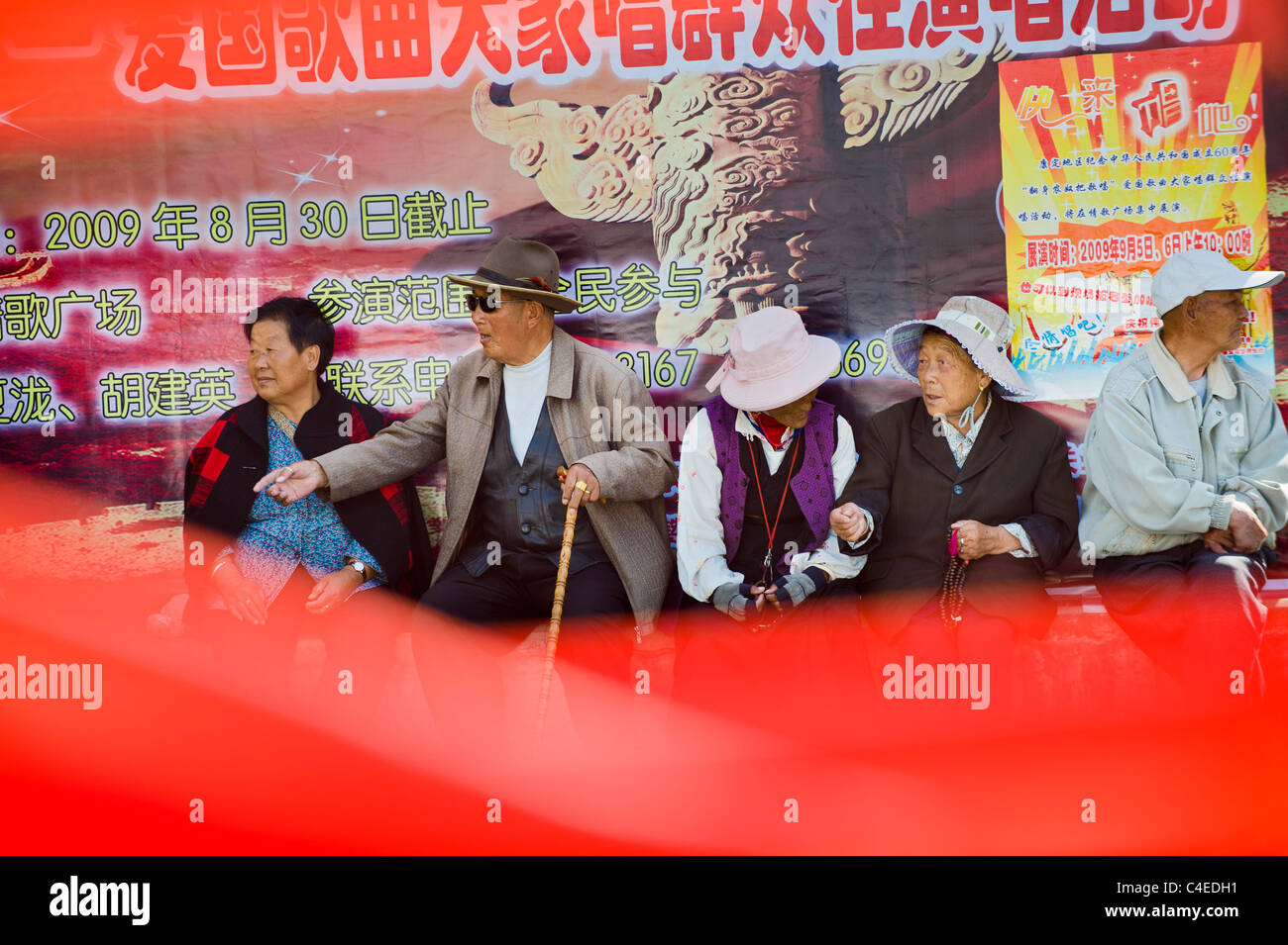 People sitting on bridge under poster advertising competition for the ...