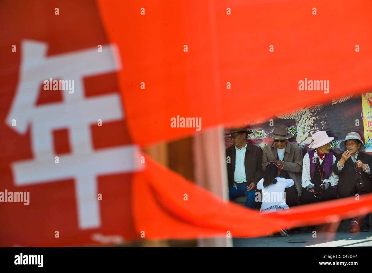 People sitting on bridge under poster advertising competition for the ...