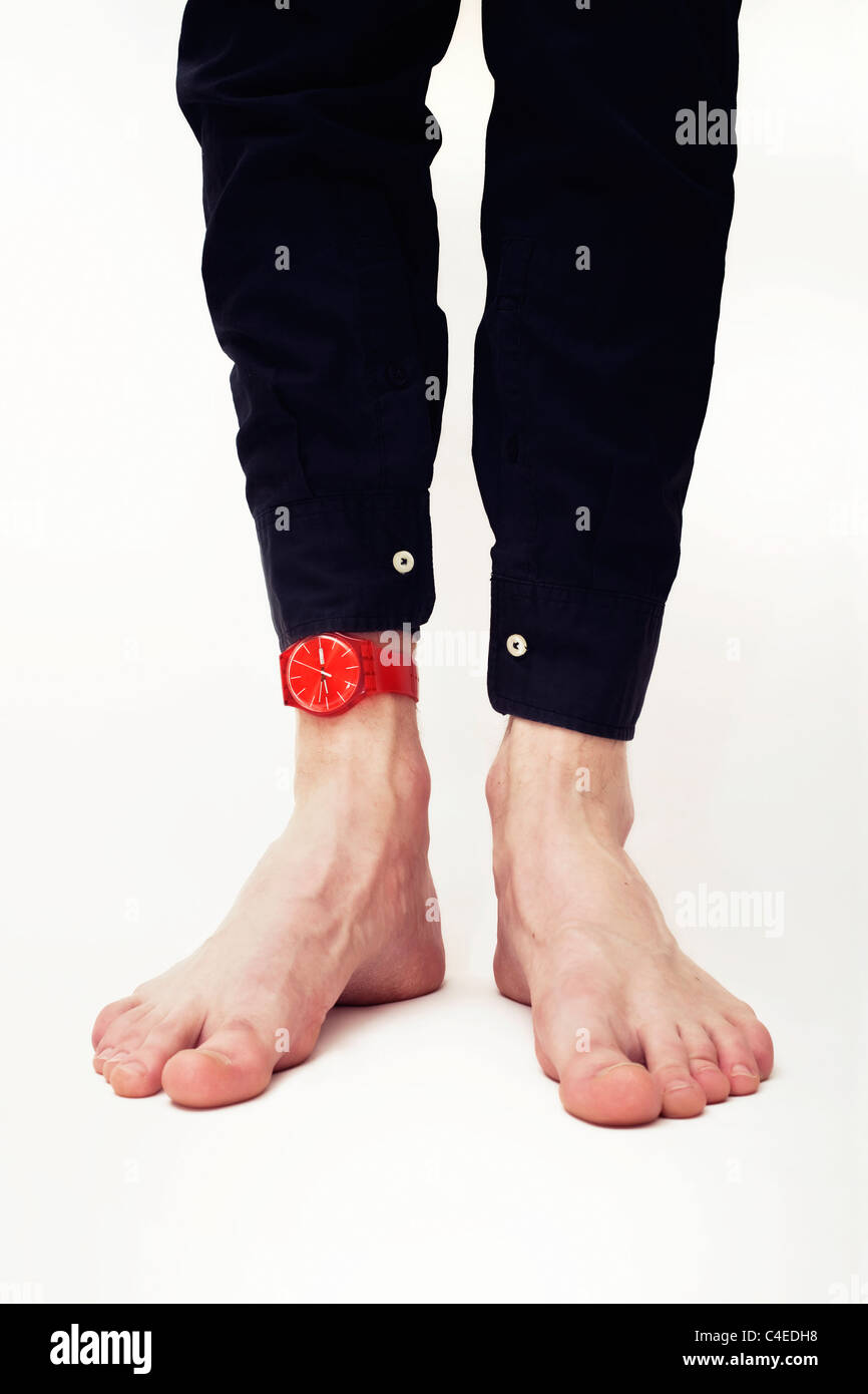 men's feet with the red clock on a white background Stock Photo - Alamy