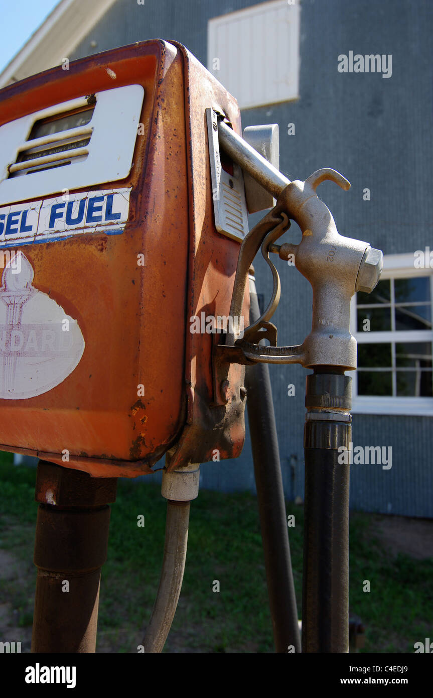 An old fuel pump sits rusting in front of decaying buildings Stock ...