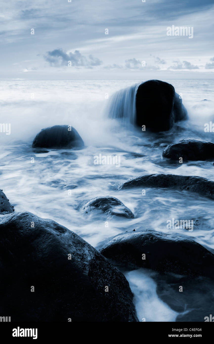Wave breaking over rocks Stock Photo - Alamy