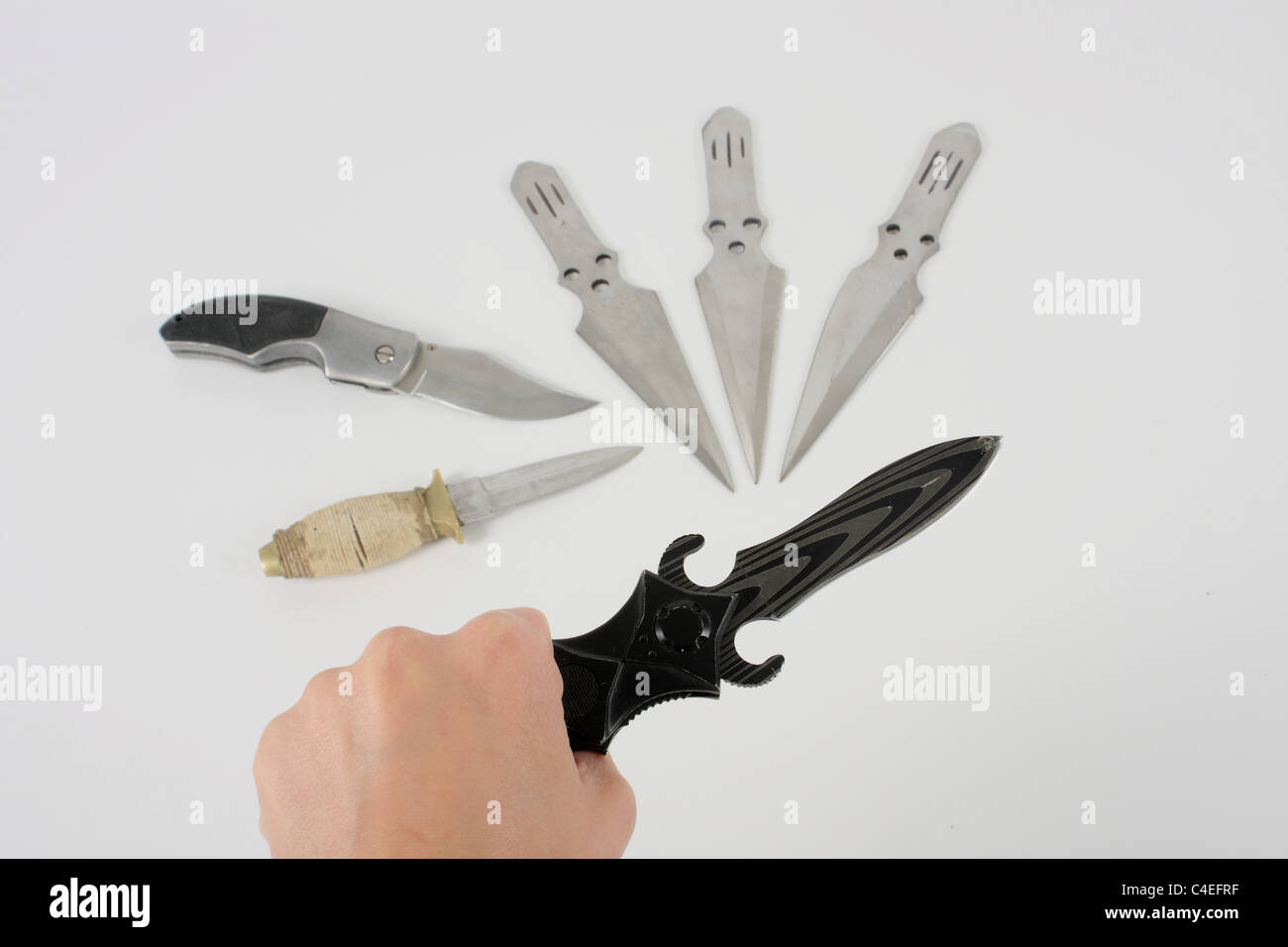 Holding a lock knife and demonstrating its use as a lethal weapon. A ...