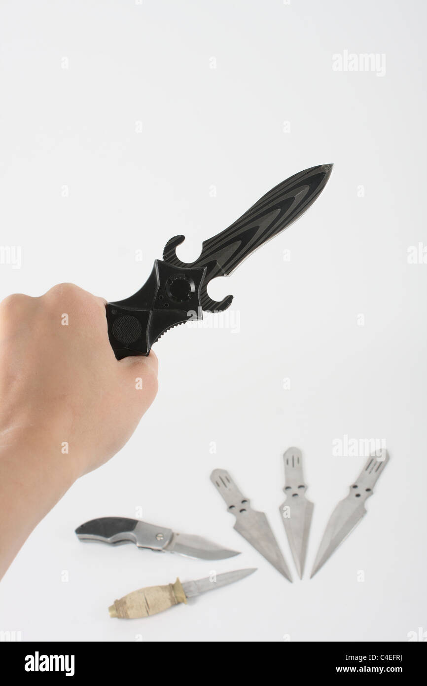 Holding a lock knife and demonstrating its use as a lethal weapon. A ...