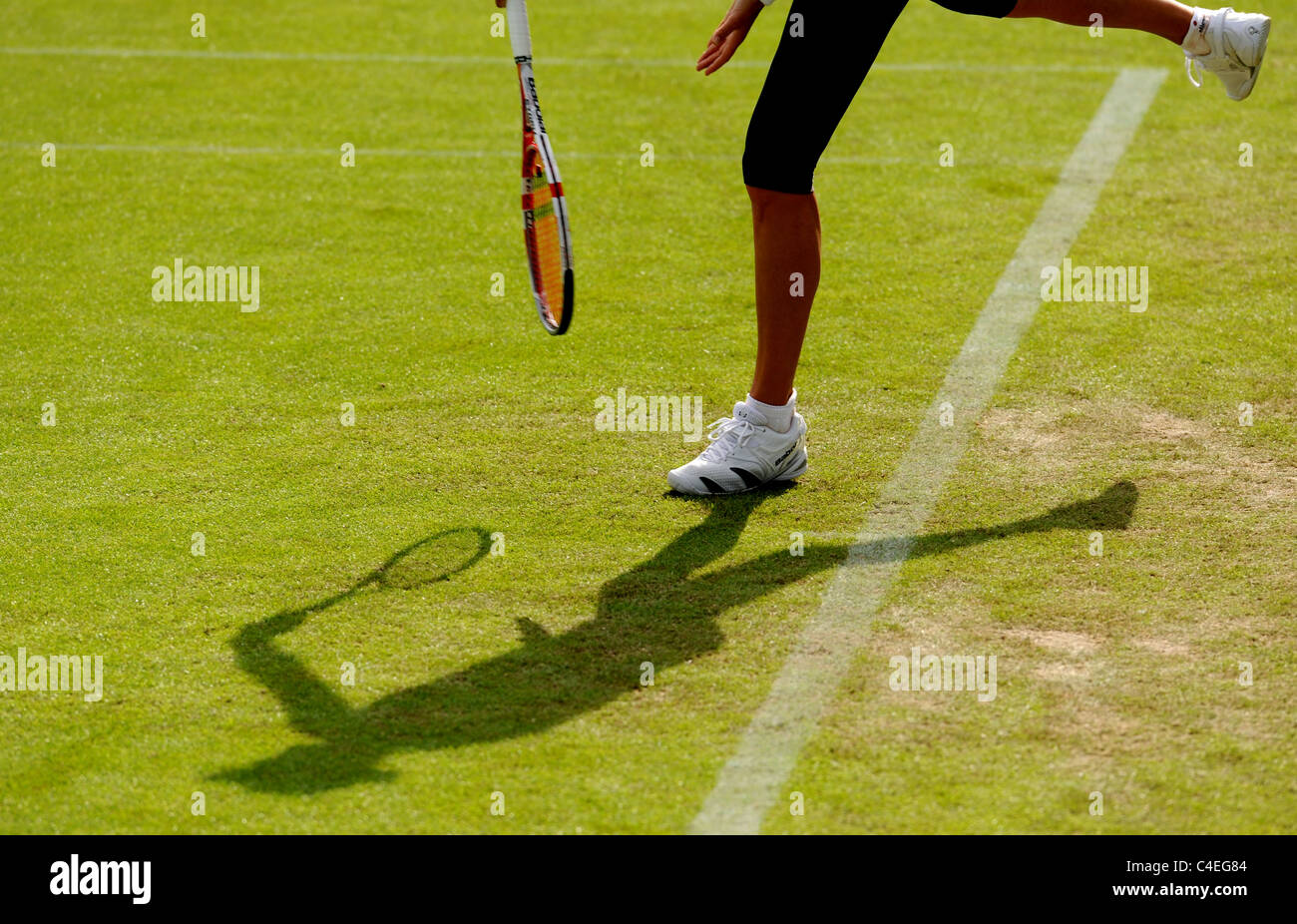 female tennis player and shadow on grass court Stock Photo - Alamy