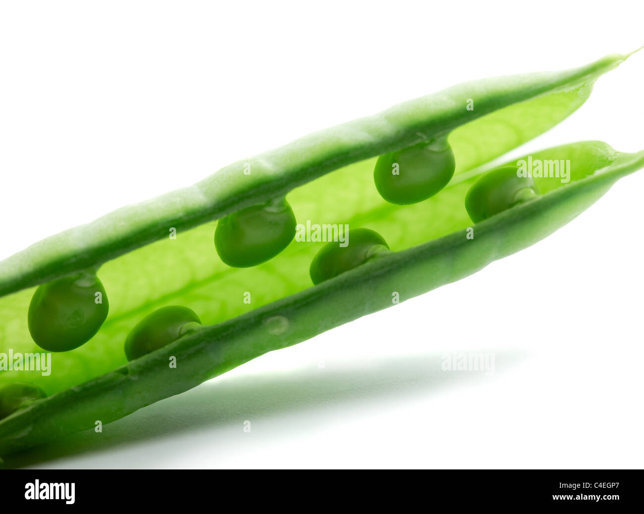 A pea pod revealing peas against white background Stock Photo - Alamy