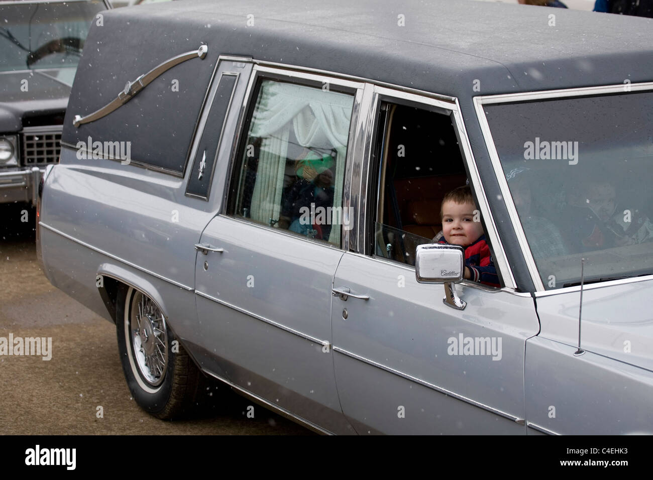 A child rides as a passenger in a hearse during a parade at the Frozen ...