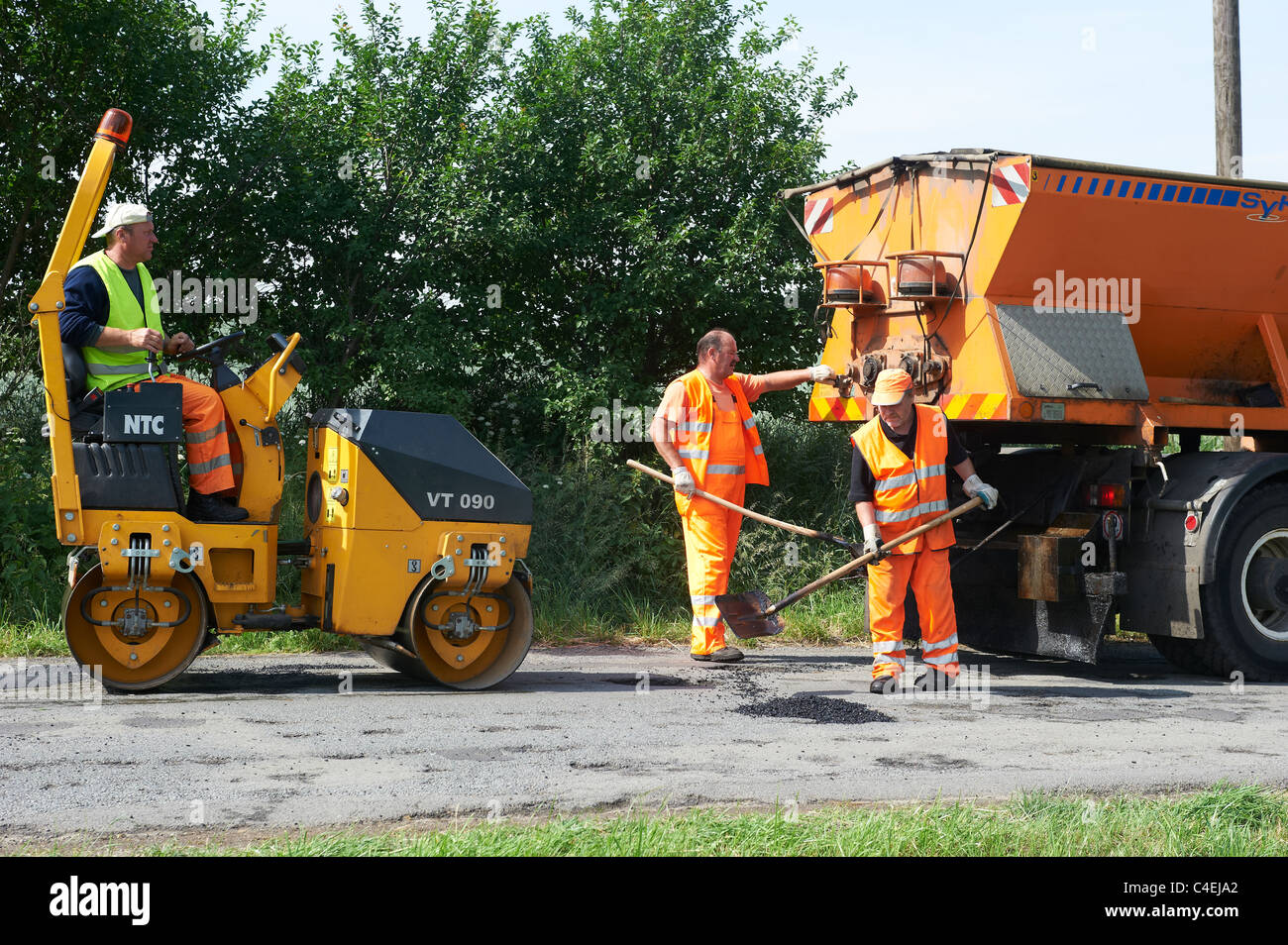 Workmen replacing damaged road surface with asphalt Stock Photo - Alamy