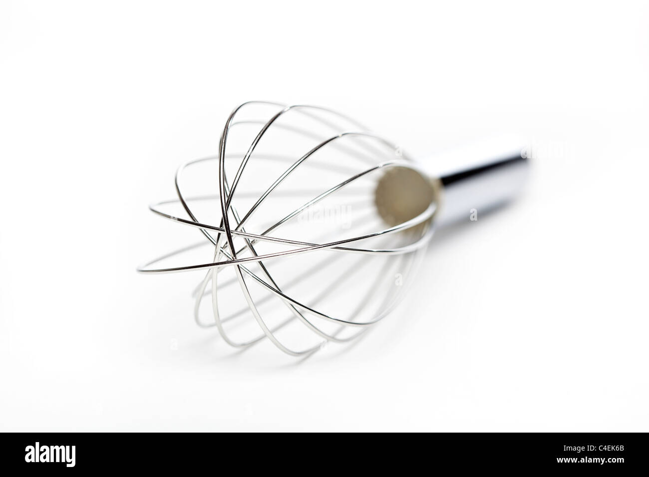 A silver whisk against a white background Stock Photo - Alamy