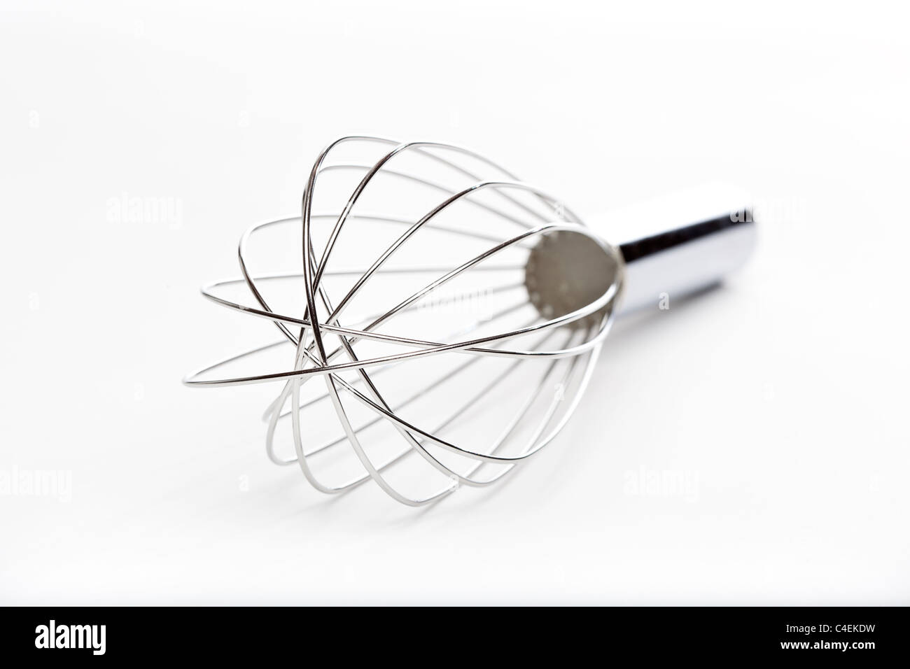 A silver whisk against a white background Stock Photo - Alamy