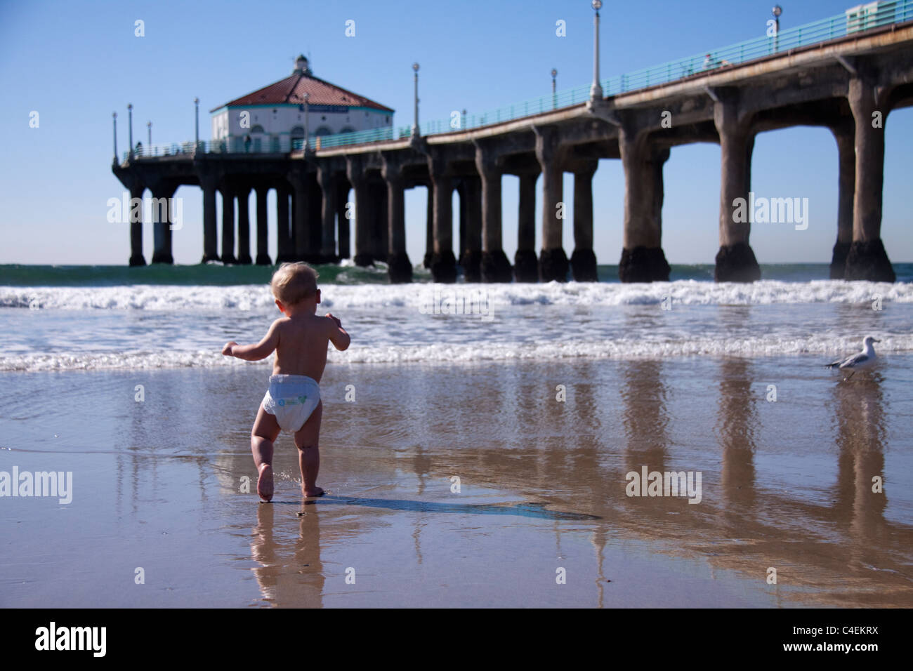 Baby running on diaper on beach towards the ocean Stock Photo - Alamy