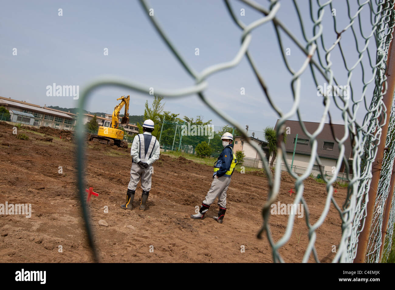 Workers remove top soil, contaminated by nuclear radiation, at school ...
